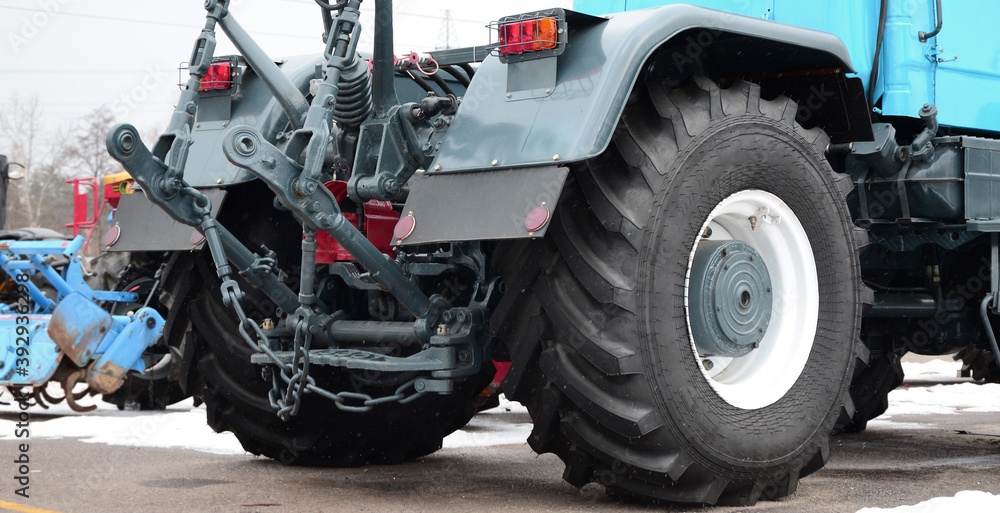 Wheels of back view of new tractor in snowy weather. Agricultural ...