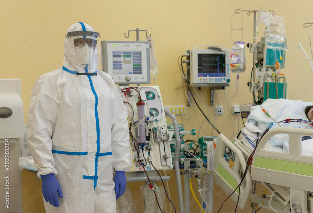 Male nurse with protective coverall clothing in intensive care unit in ...