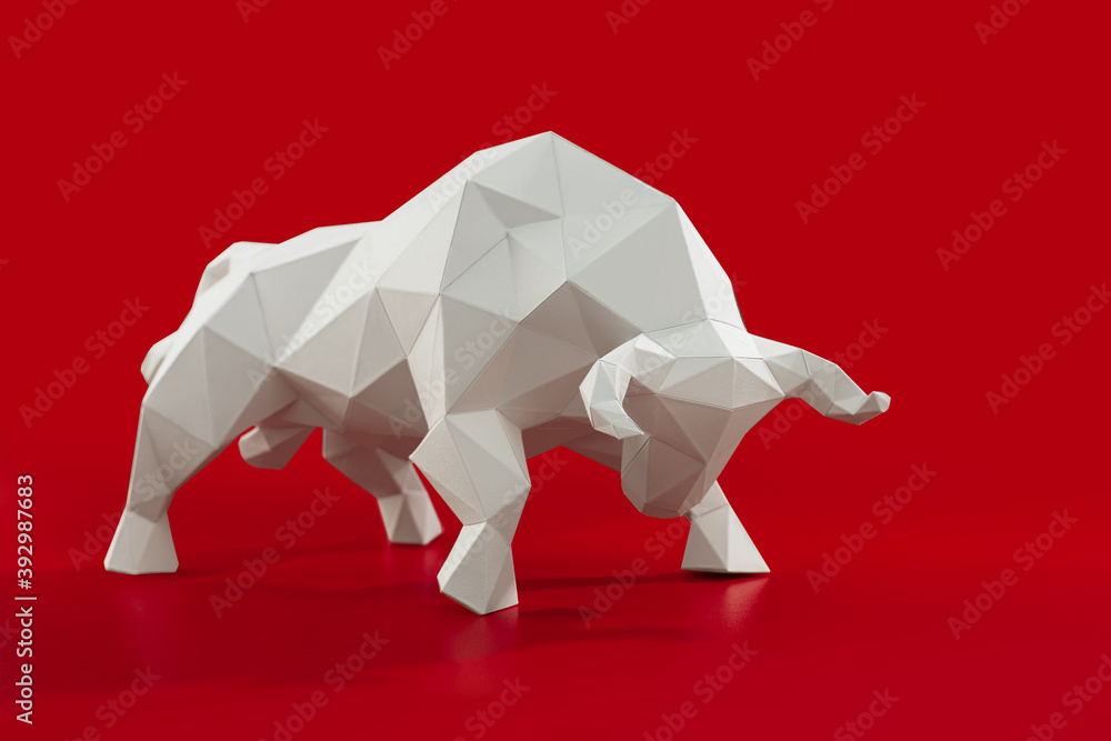 White volumetric paper bull papercraft on a red background, symbol of ...