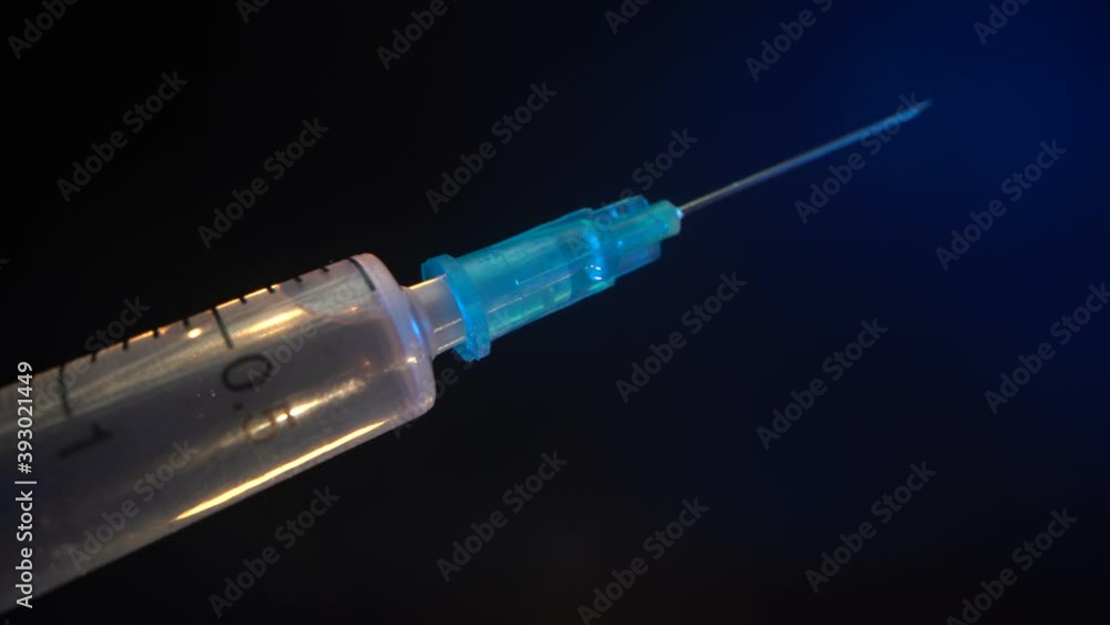 Close-up of a new disposable syringe with a closed cap on a needle. The ...