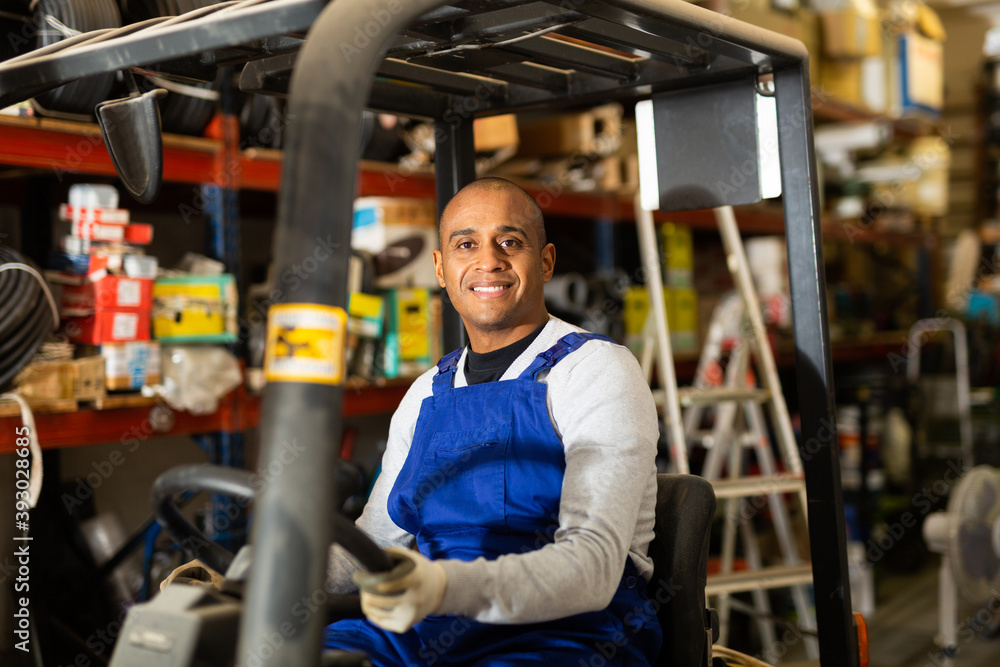 Cheerful Latin American worker of building materials warehouse working ...