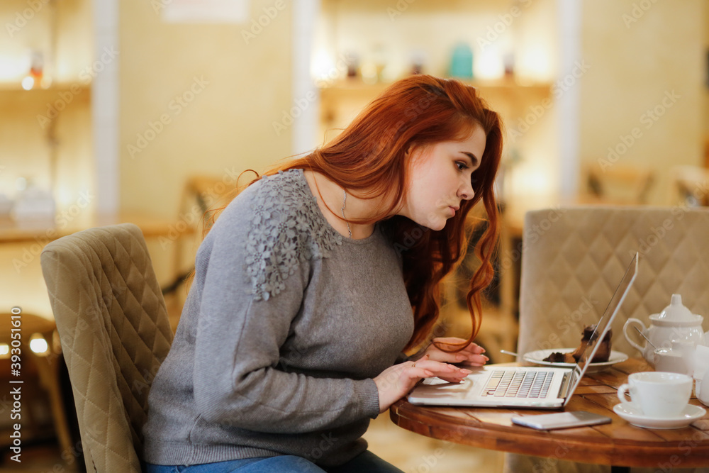 Caucasian beautiful plus size lady overweight woman works with a laptop ...
