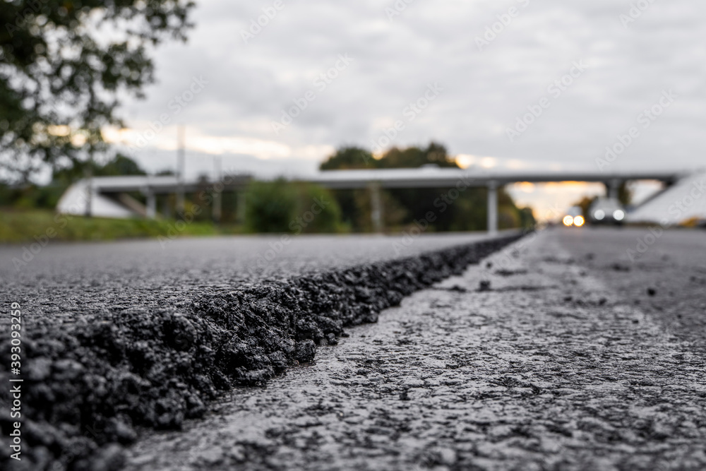 A large layer of fresh hot asphalt. Layer of asphalt raw material in a ...