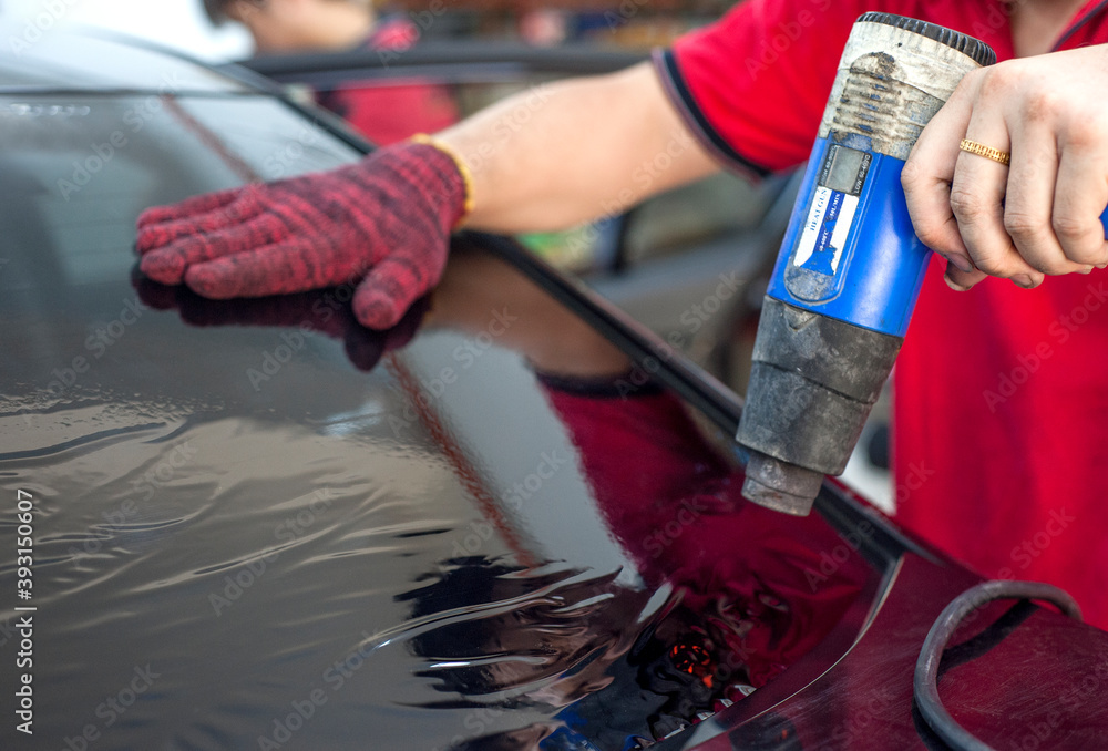 Car window tinting specialist attaching Tinting Film to car rear ...