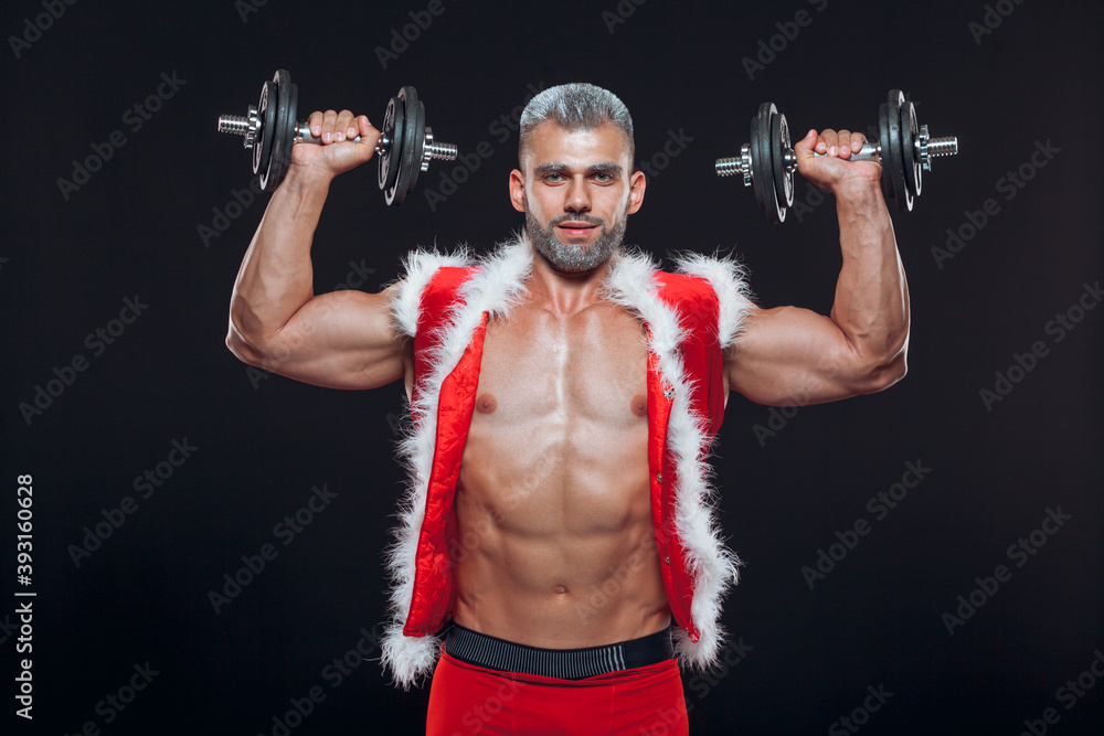 Sexy Santa Claus. Bodybuilder young handsome santa clause smile holds a ...