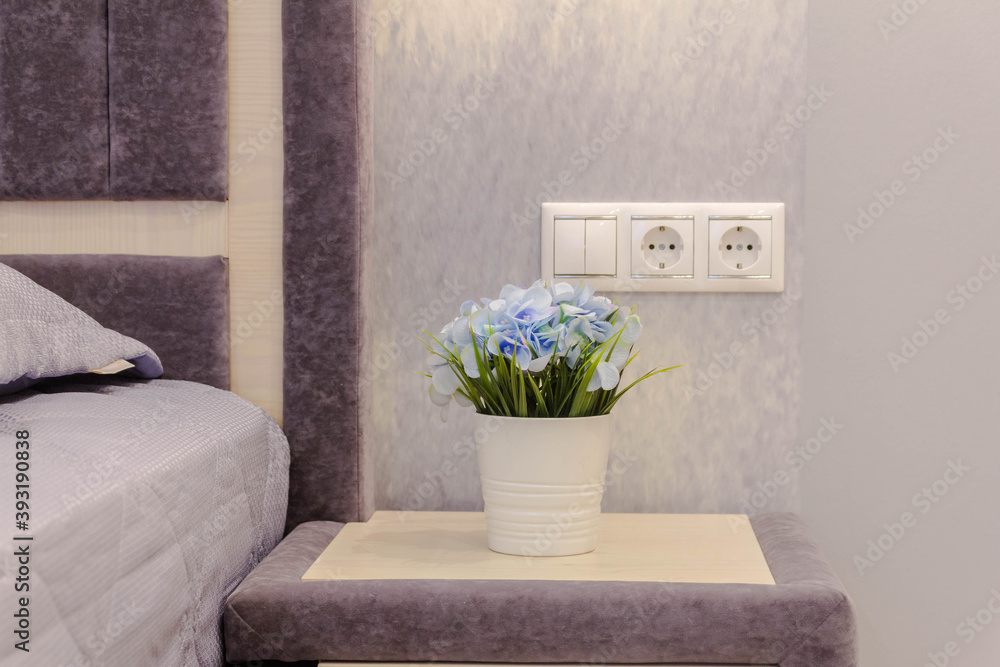 planters with a bouquet of flowers on the bedside table in a modern ...