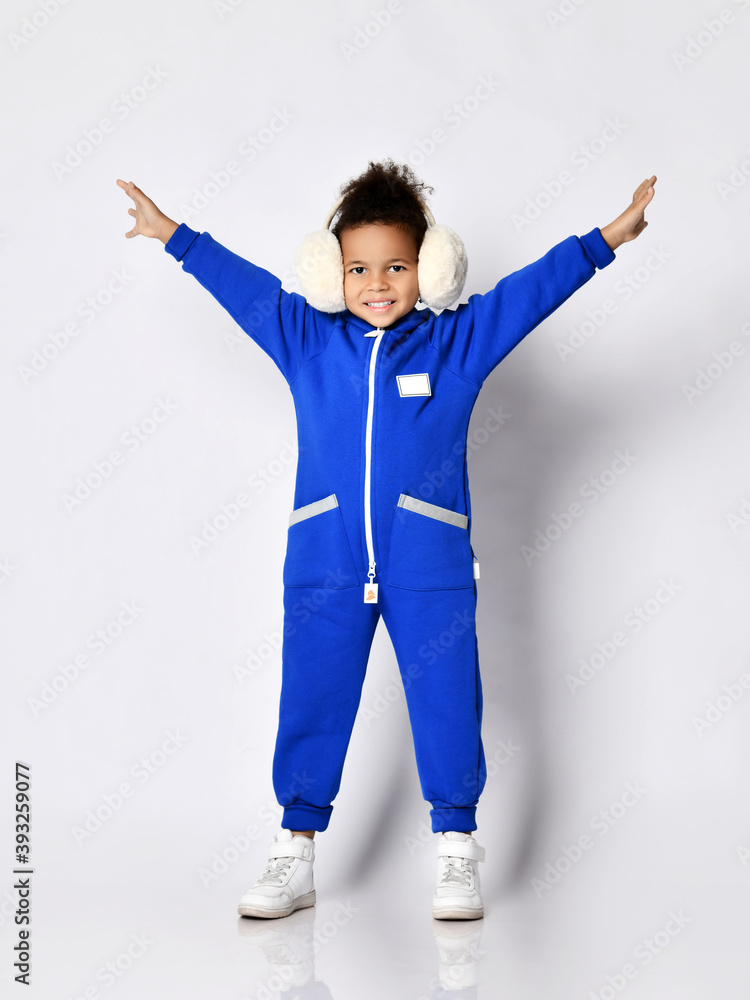 Happy smiling healthy sporty dark-skinned kid girl in warm blue ...