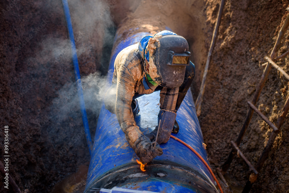 The welder is working Connecting large water pipelines in the ...