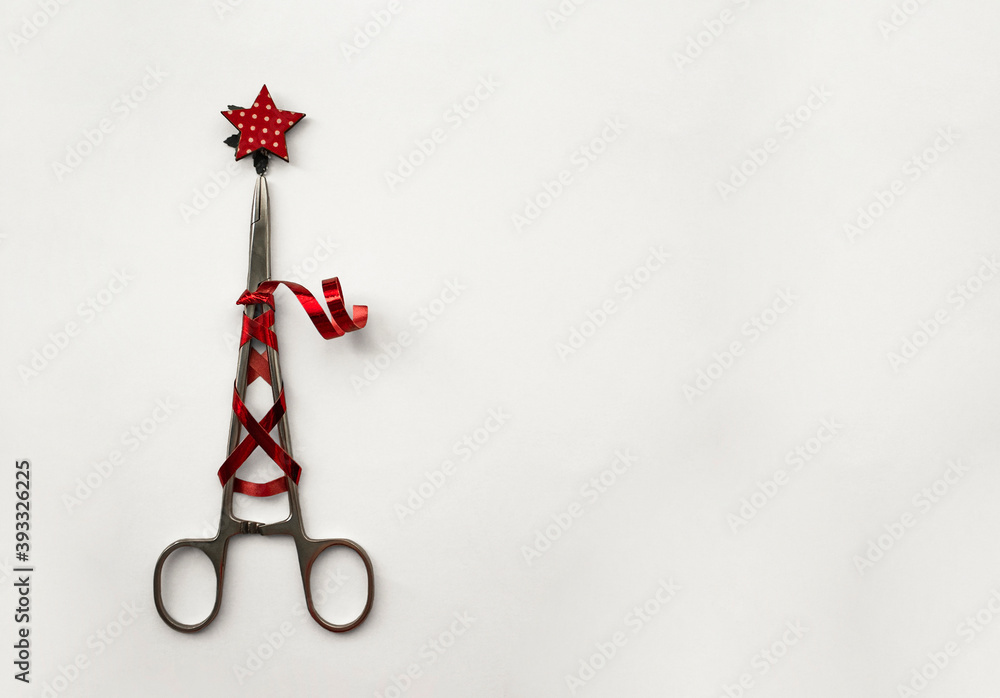 Surgical clip with festive red ribbon and star. Christmas tree made of ...