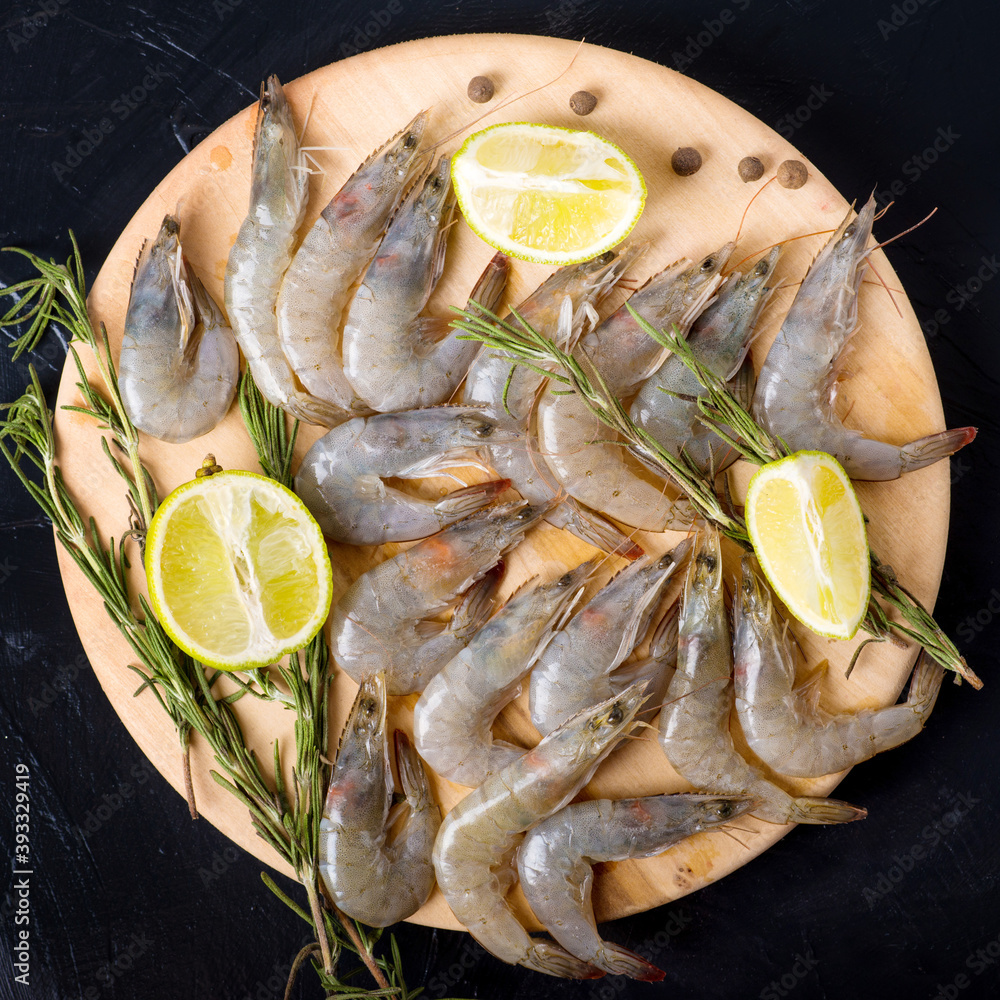 Raw black tiger prawns with lemon. Seafood. On a black background Stock ...