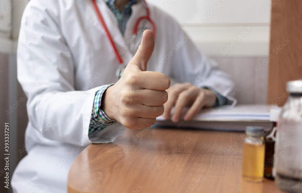Thumbs up symbol by smiling young confident doctor. Health care concept ...