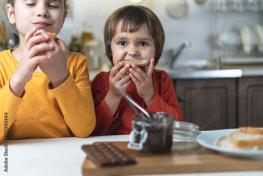 Sister and brother alone in the kitchen have breakfast on their own ...