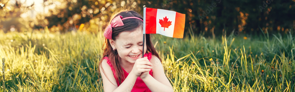 Funny Caucasian girl holding Canadian flag. Laughing child in park ...