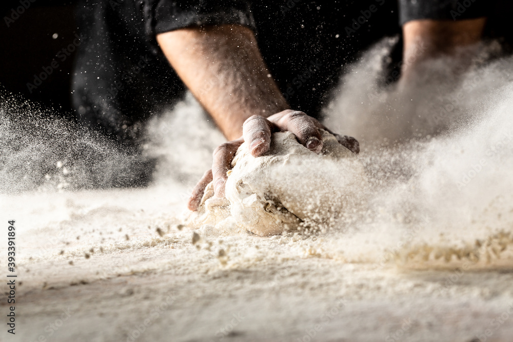 Powdery flour flying into air. chef hands with flour in a freeze motion ...