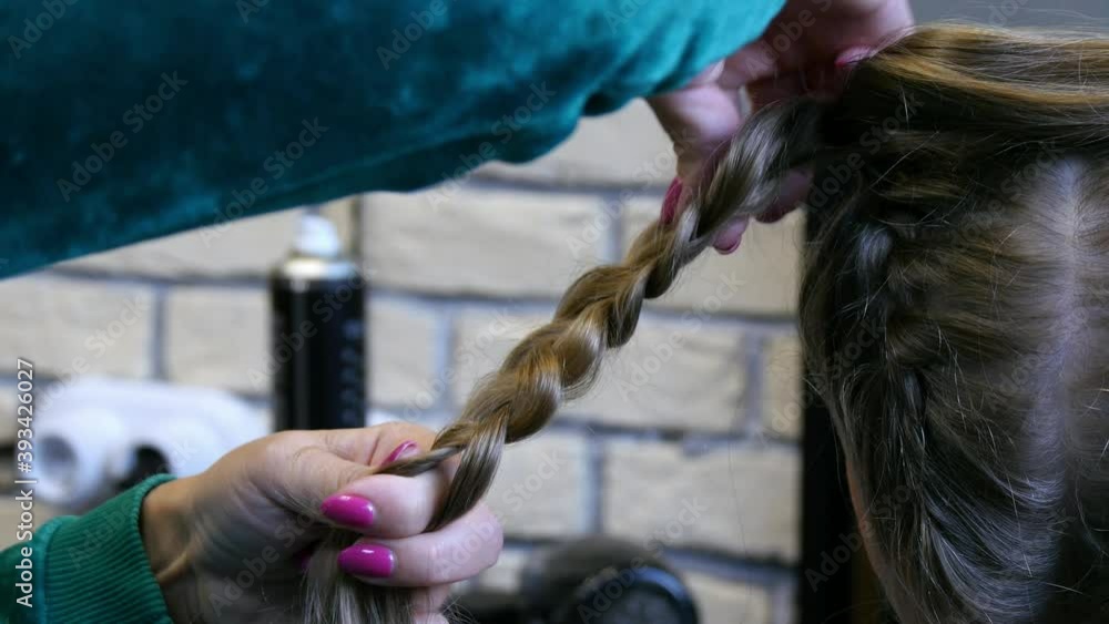 Close up fashion beauty braiding braids in hair salon. Working as ...