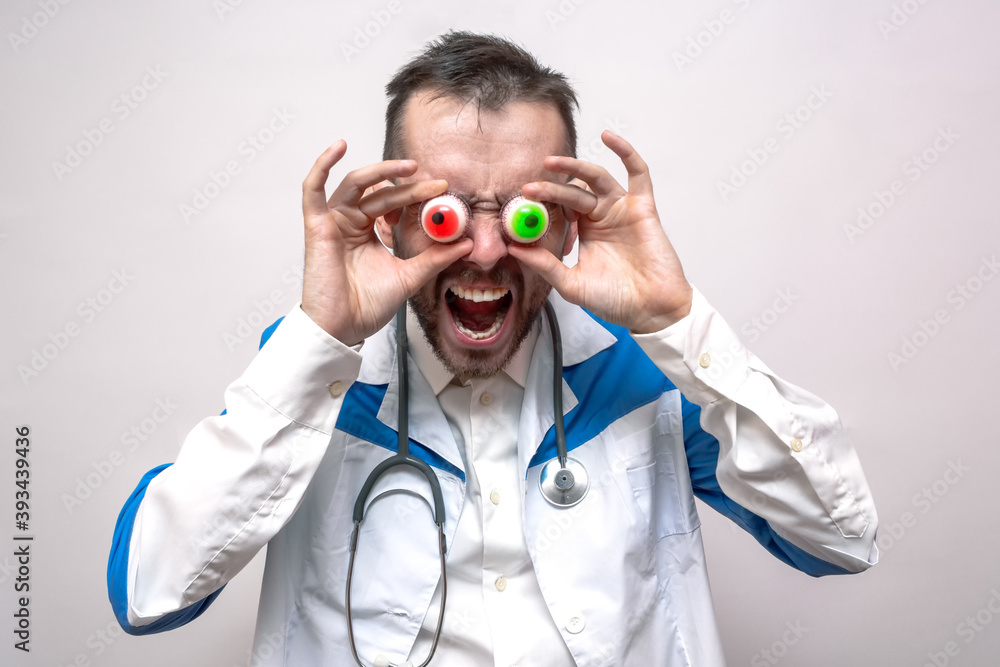 Evil doctor holds colored eyeballs near his face. Concept of a creepy ...