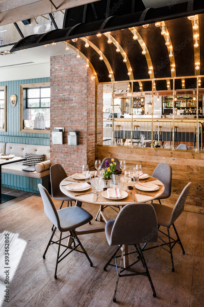 Front view of modern restaurant in wooden tonnes and light bulbsin loft ...