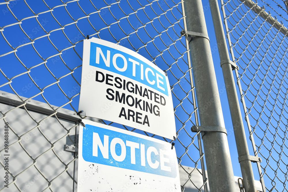 An image of a blue and white designated smoking area sign posted to a ...