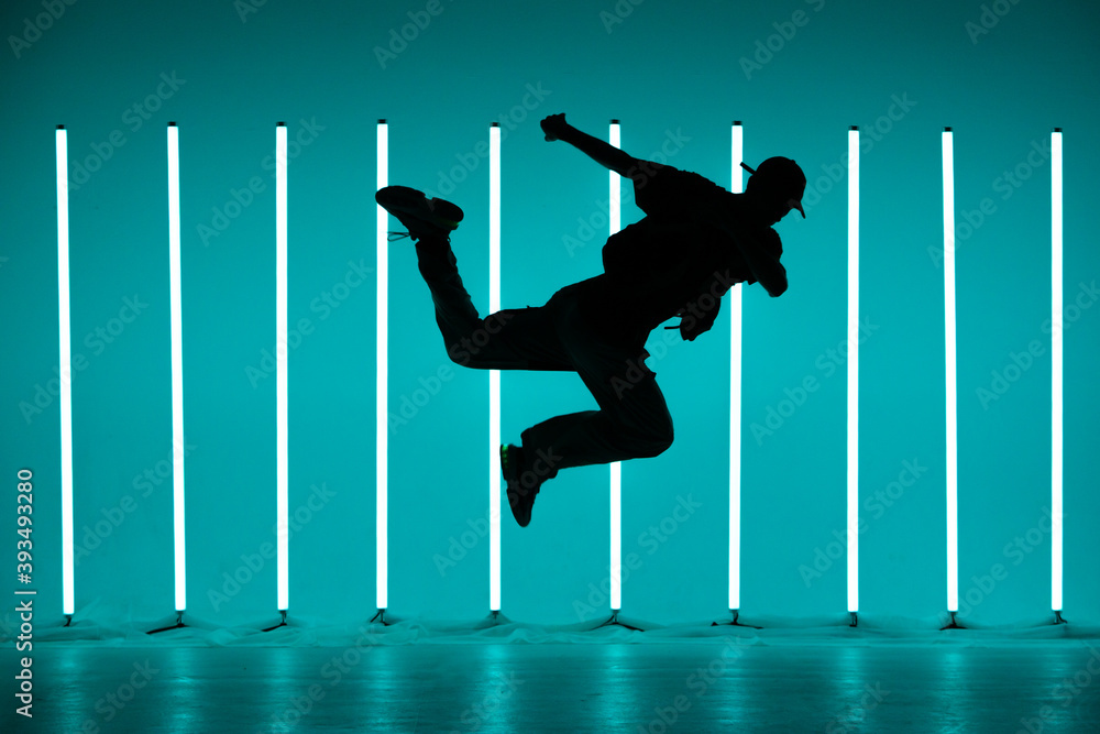 Full size of silhouette of male break dancer performing on blue neon ...