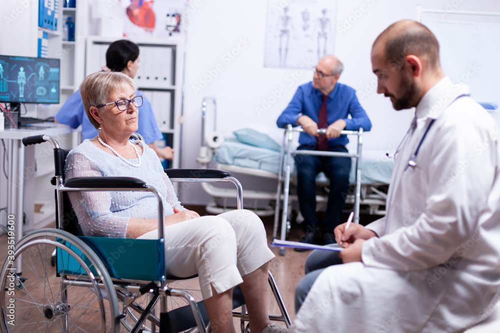 Foto de Disabled old woman in wheelchair talking about rehabilitation ...