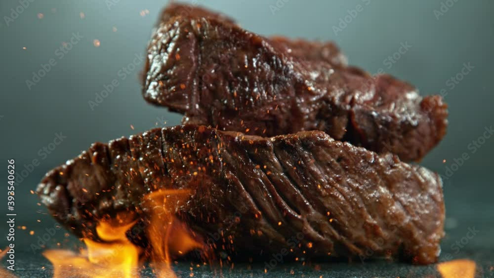 Close-up of falling tasty beef steak, super slow motion, filmed on high ...