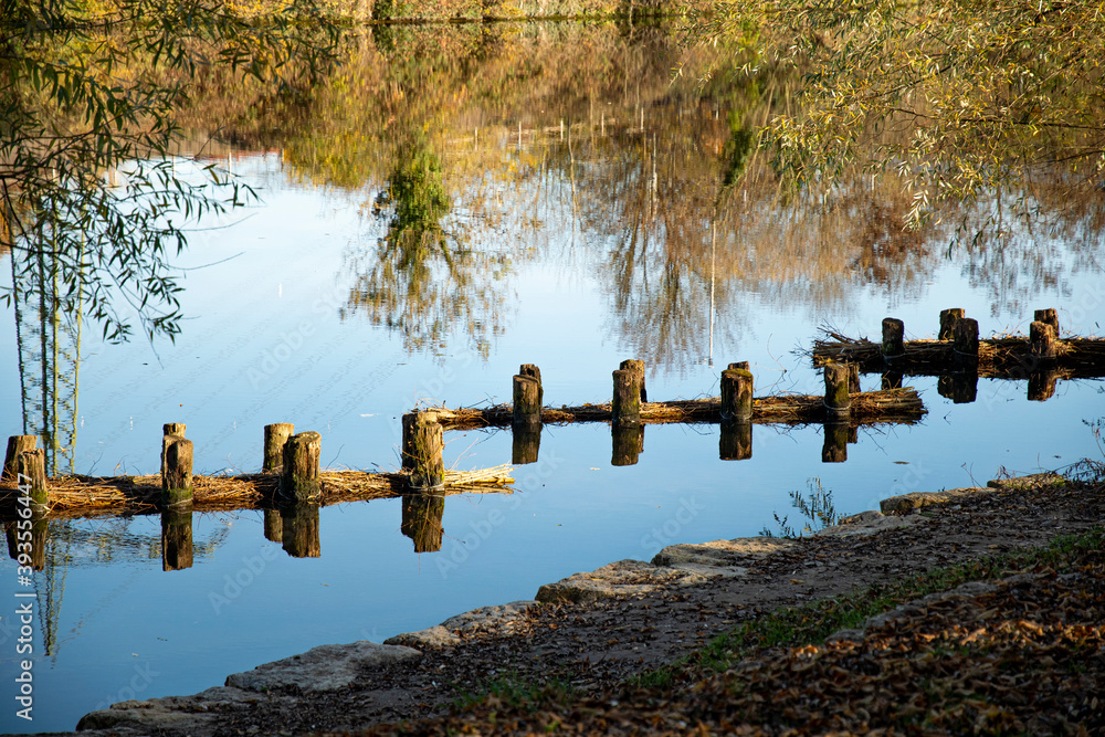 River idyll with mooring posts for canoes Stock Photo | Adobe Stock
