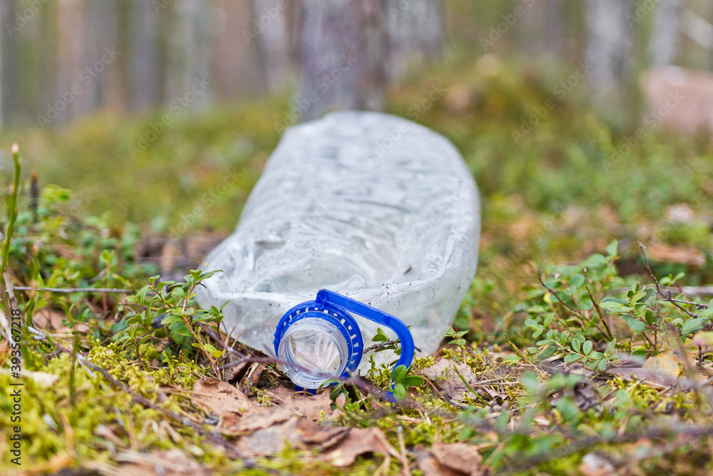 thrown plastic bottle in the middle of the forest, environmental ...