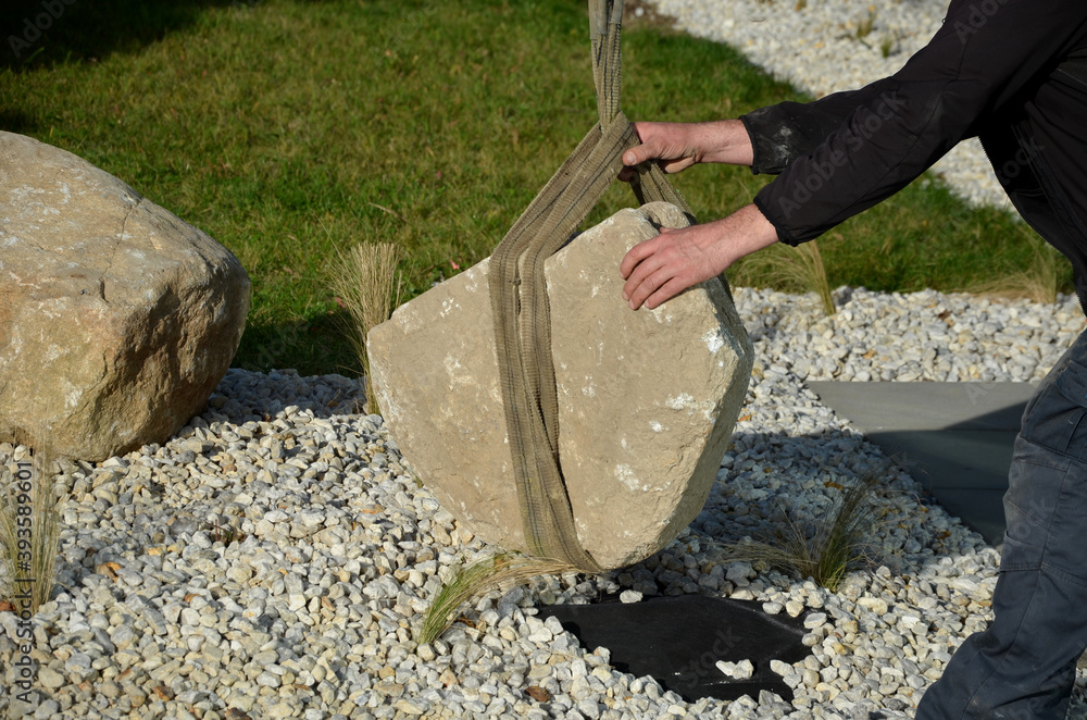 safe handling of a very heavy granite boulder with a crane, the stone ...
