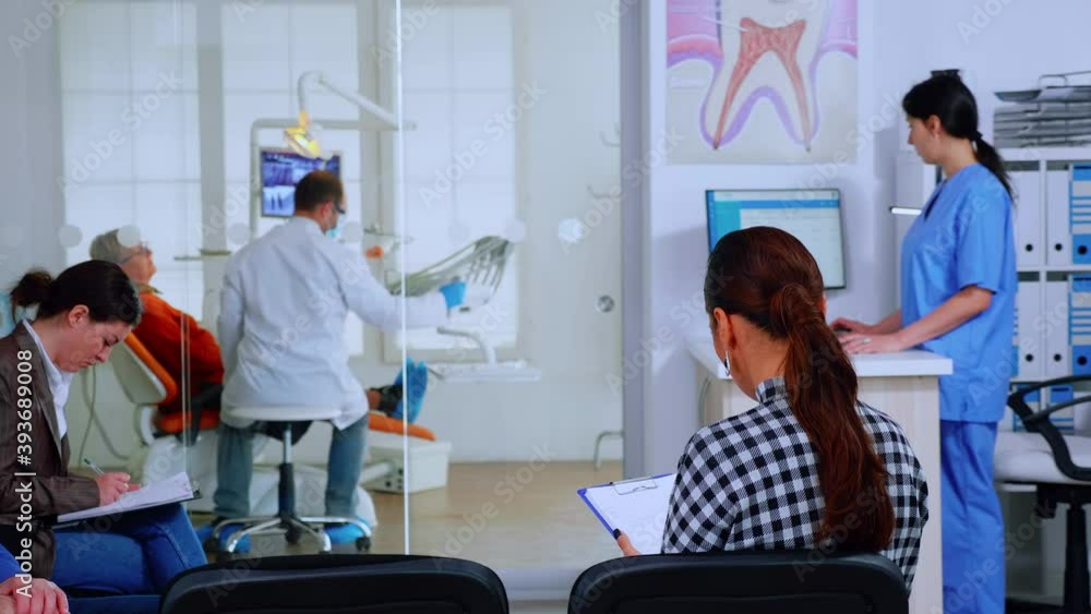 Back view of woman filling in dental document sitting on chiar in ...