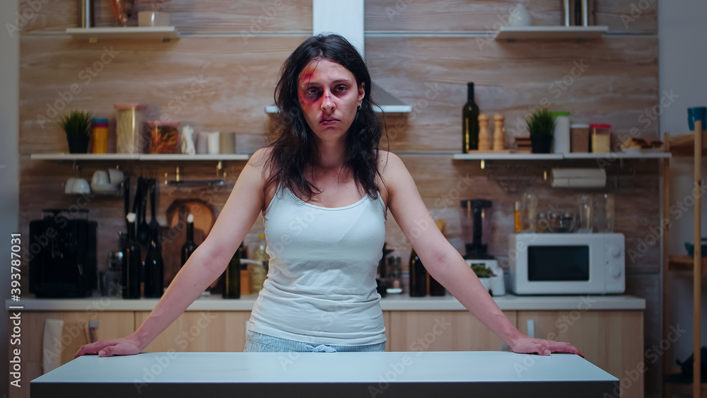 Woman victim screaming and crying desperately sitting in the kitchen ...