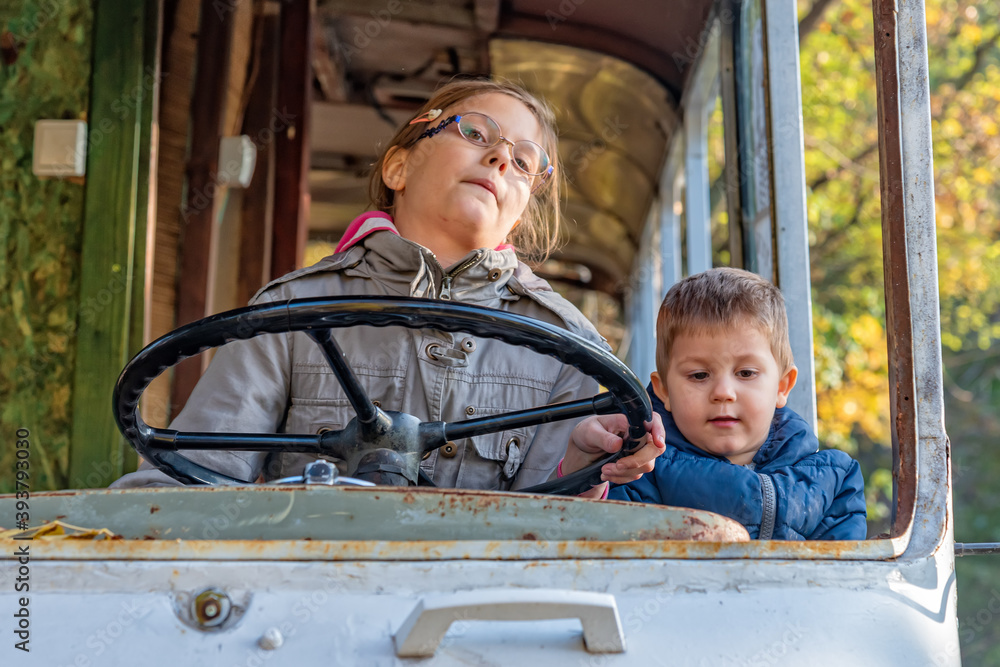Childrens play in an abandoned bus. A girl drive a bus. The girl turns ...