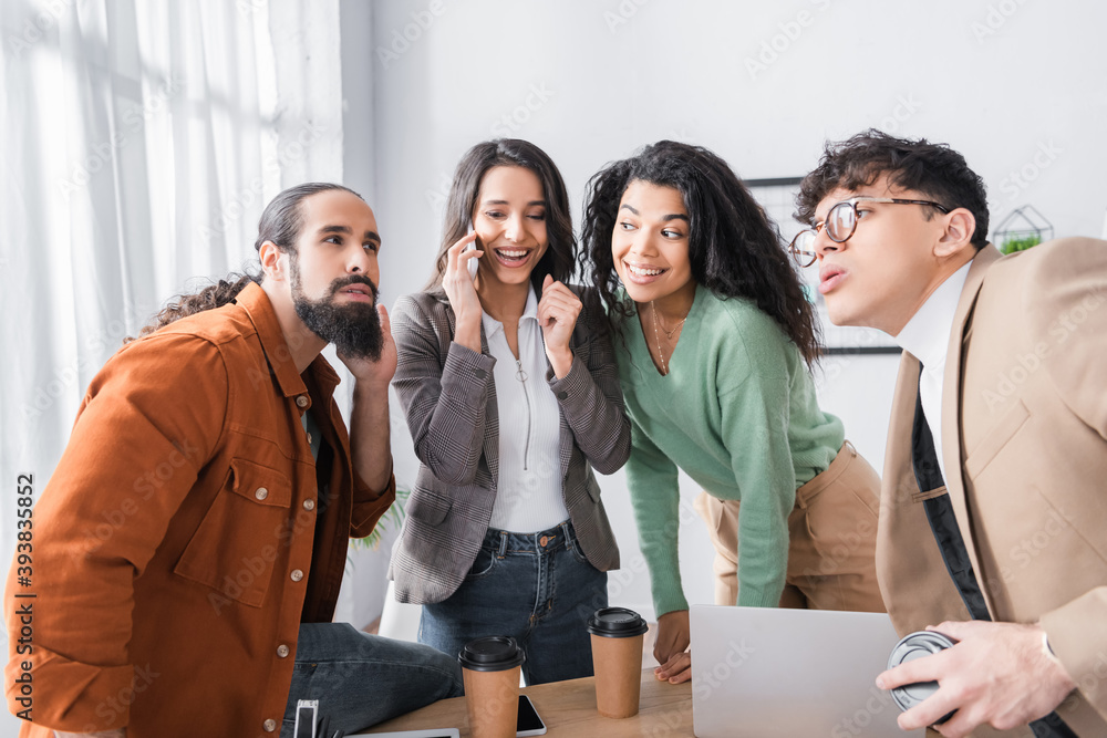 Curious hispanic office workers standing together and eavesdropping ...