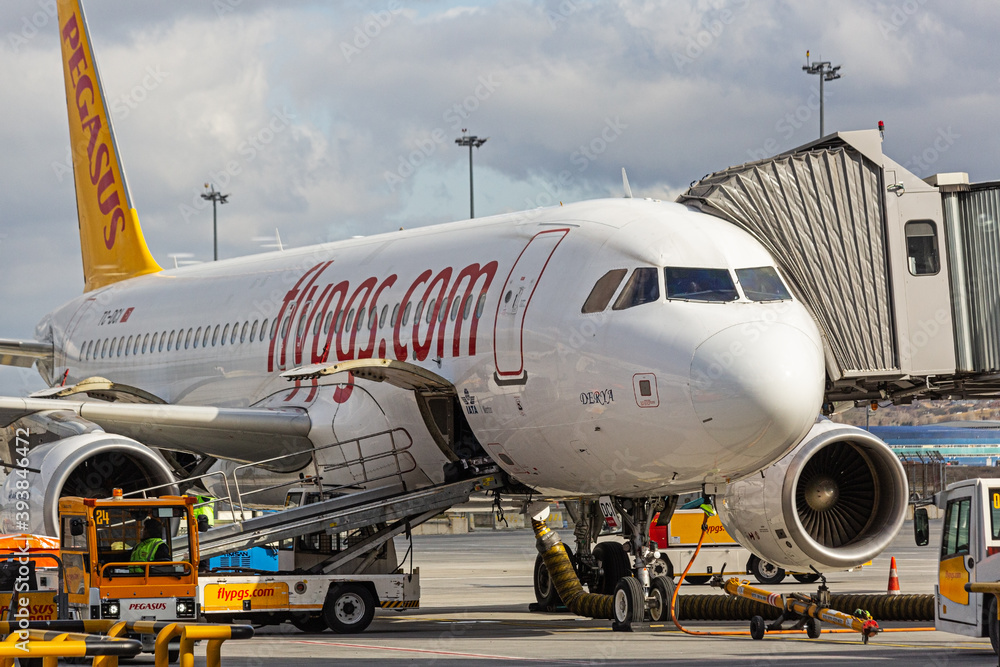 Cargo truck and passenger boarding bridges connected to an Airbus A320 ...