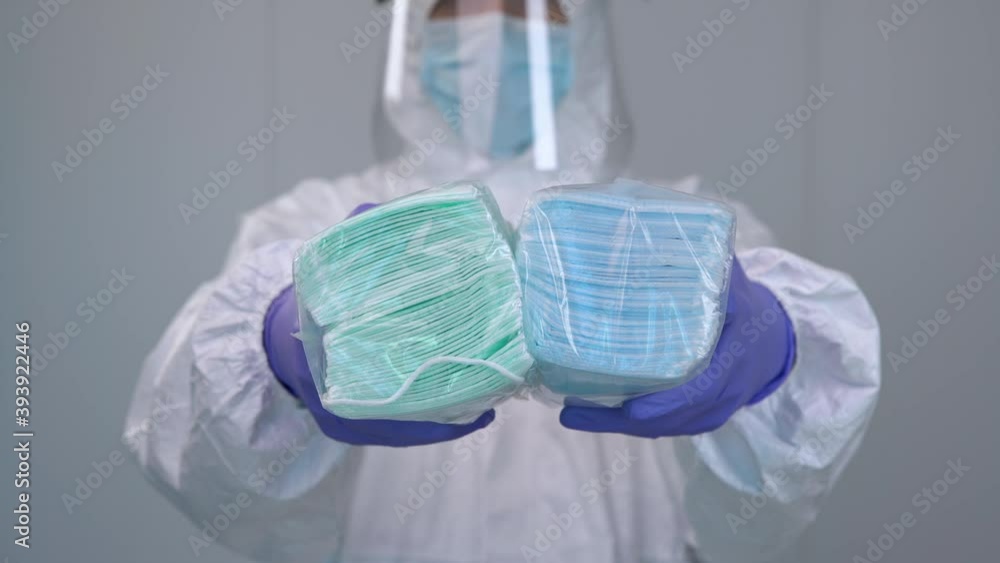 4K, Doctor in PPE with plastic face shield shows the packing of a new ...