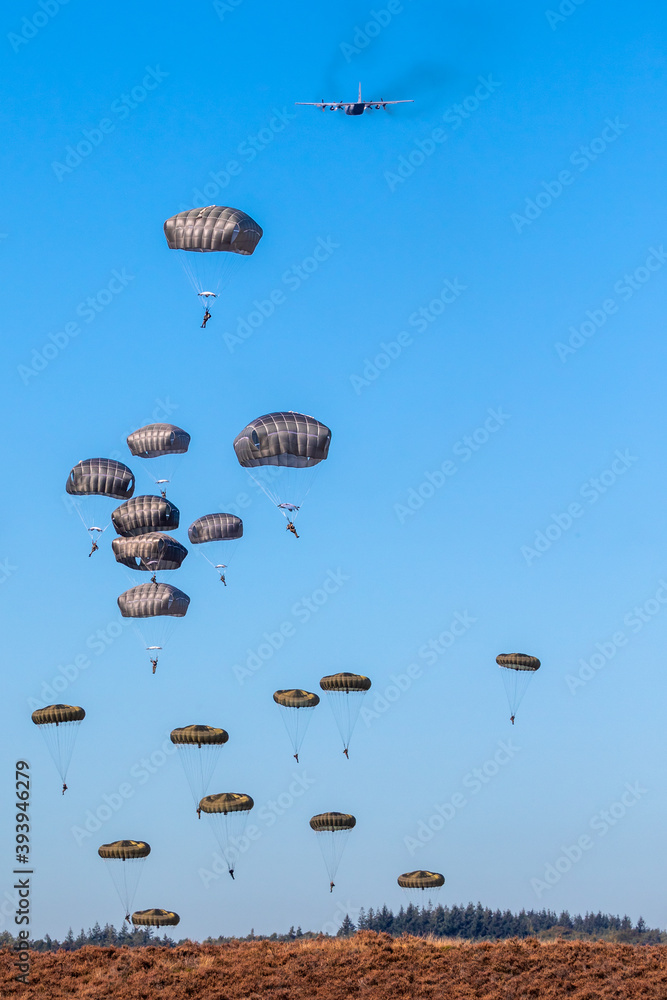 Military parachutist paratroopers parachute jumping out of a air force ...
