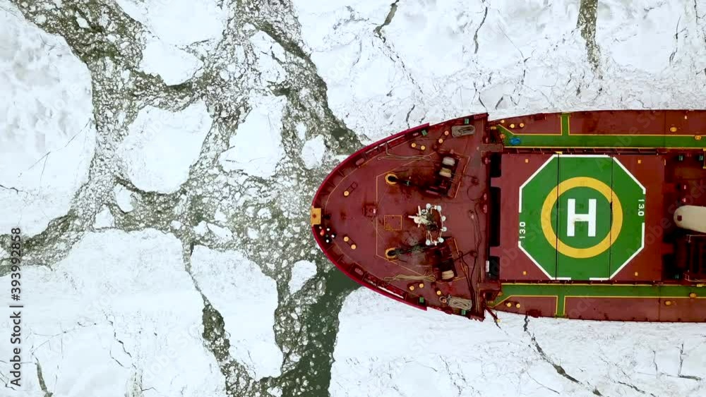 Aerial above epic huge steel ship breaks ice by bow of ship and floats ...