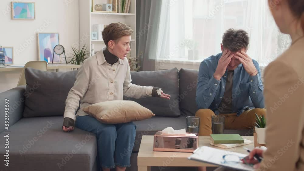 Medium long over shoulder of Caucasian family couple fighting sitting ...
