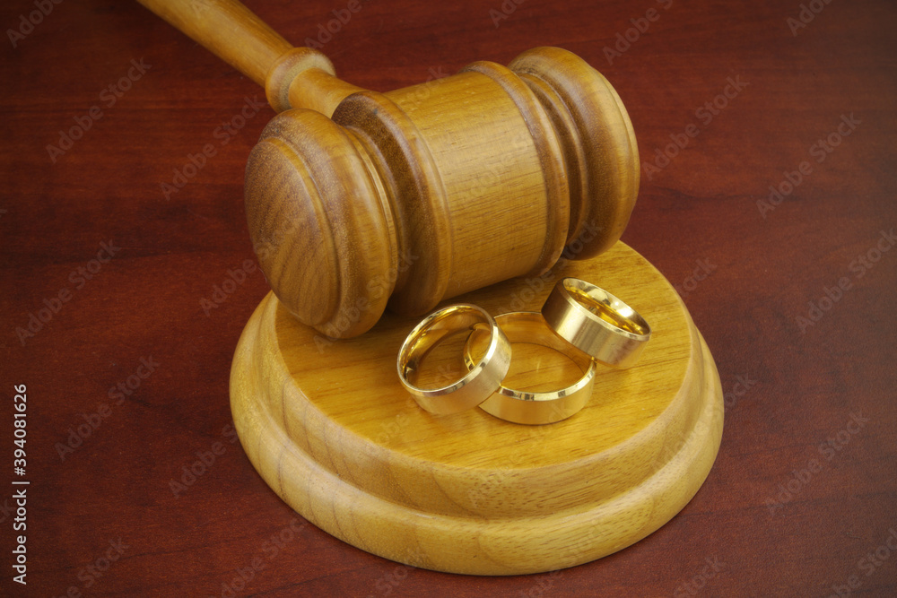 Bigamy concept, two wives wedding ring and one husband ring with judge ...