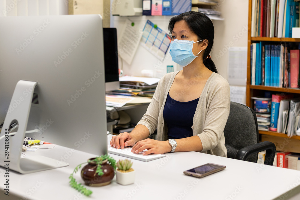 asian office lady with face mask using computer during covid-19 period ...