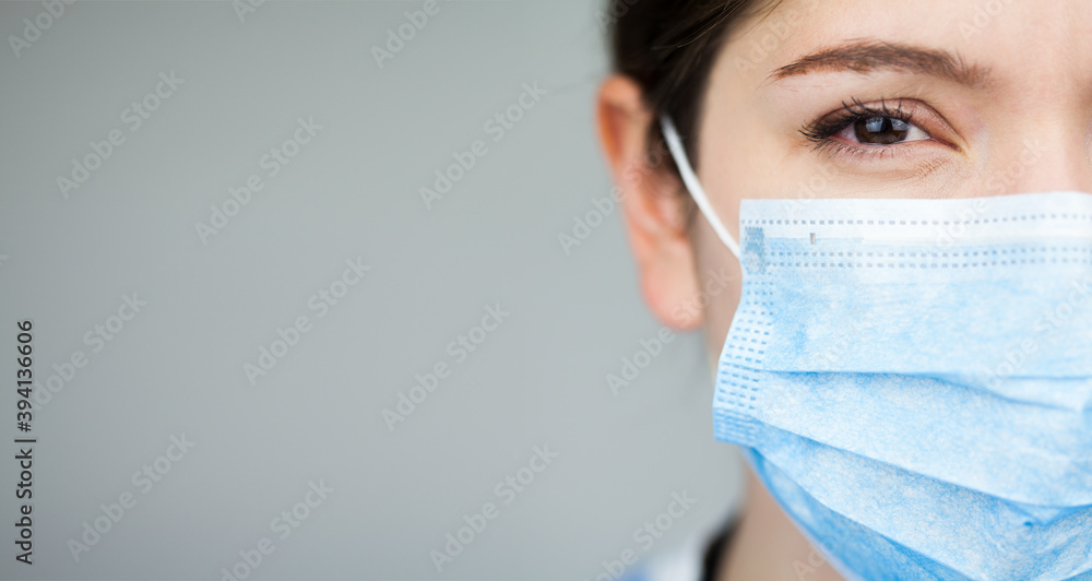 Close up of female UK NHS EMS doctor's face,wearing blue PPE surgical ...