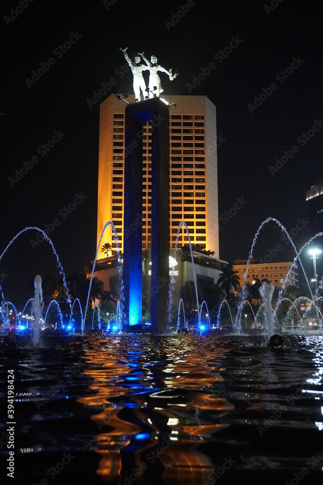 Colorful fountain show at iconic statue of Patung Selamat Datang at ...