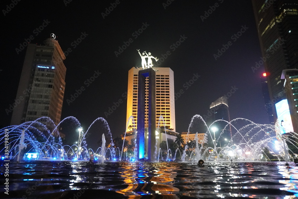 Colorful fountain show at iconic statue of Patung Selamat Datang at ...