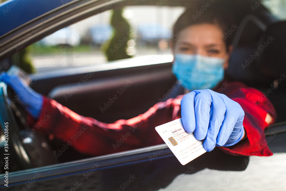 Young female driver showing Coronavirus health card or immunity ...