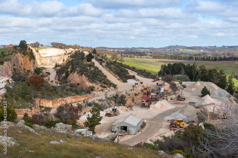 Trucks and machinery working at a stone quarry, exploitation of natural ...