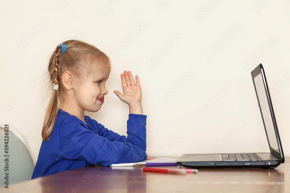 The little girl looks intently at the computer monitor and raises her ...