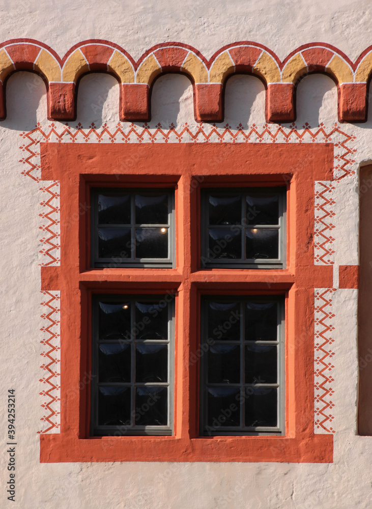 Colorful romanesque round arch frieze and Renaissance window on a ...