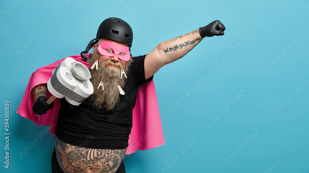 Strong powerful bearded superhero wears cloak eye mask and helmet keeps ...