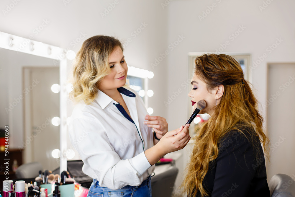 Young girl/woman making makeup in dressing makeup room. Make up process ...