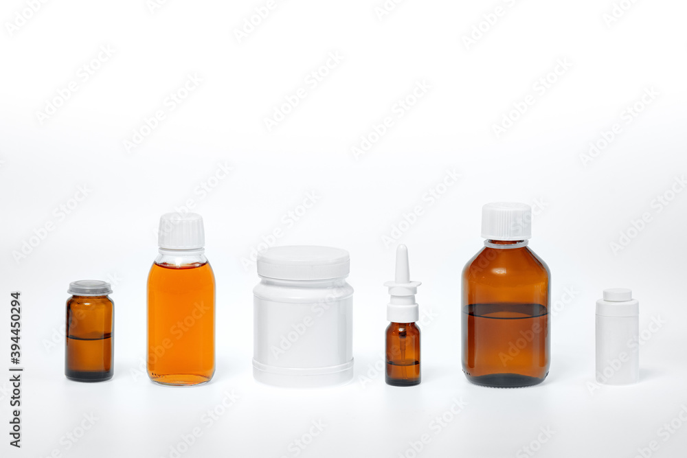 glass jars and white plastic medical containers on a white background ...
