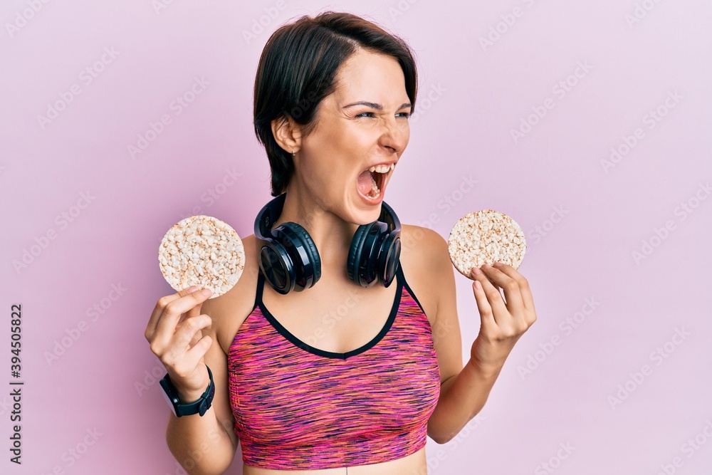 Young brunette woman with short hair wearing sportswear holding rice ...